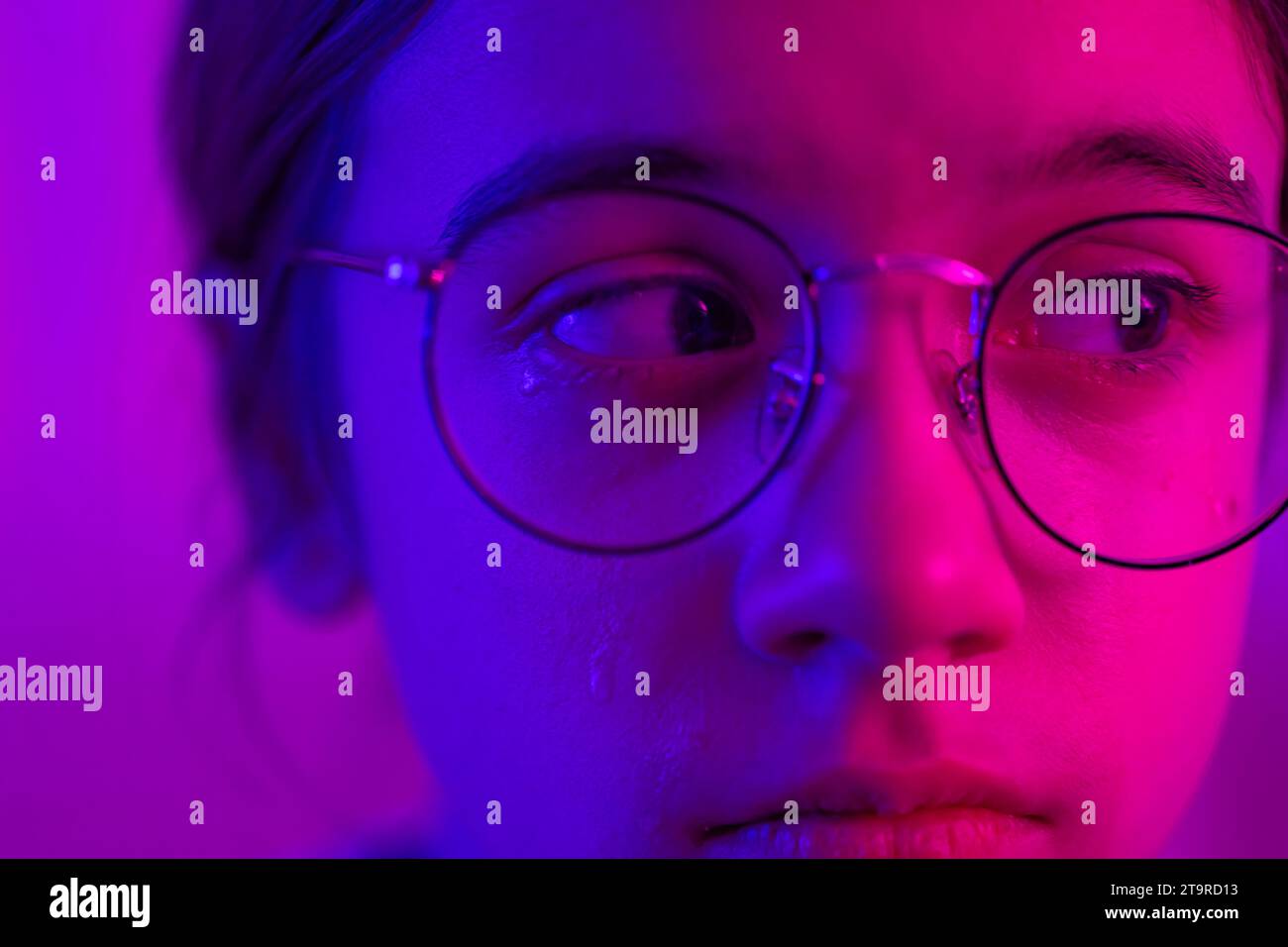 Cute girl with glasses crying in neon light, face close-up Stock Photo ...