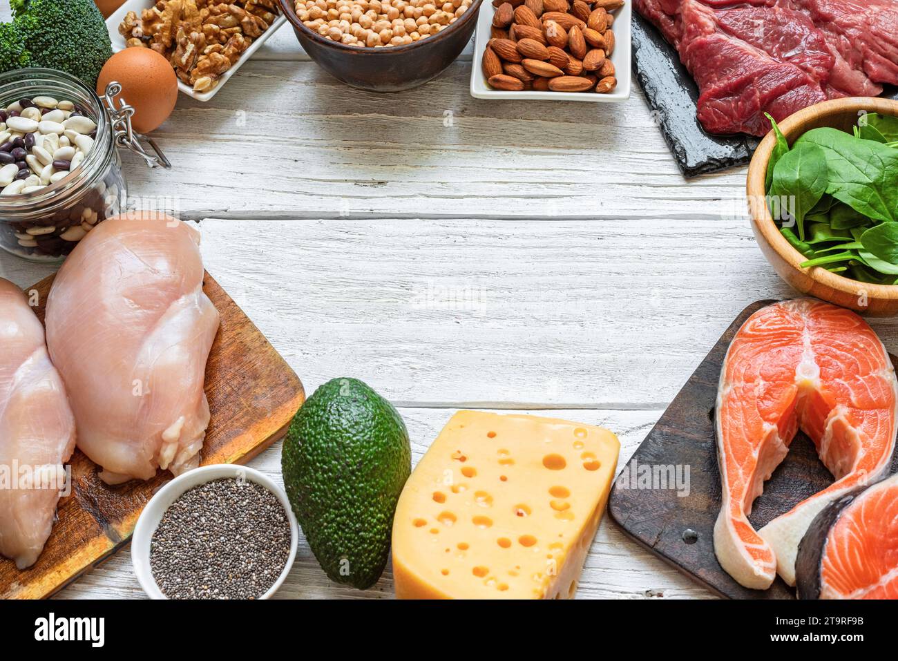 Frame made of high protein food sources on white wooden background ...
