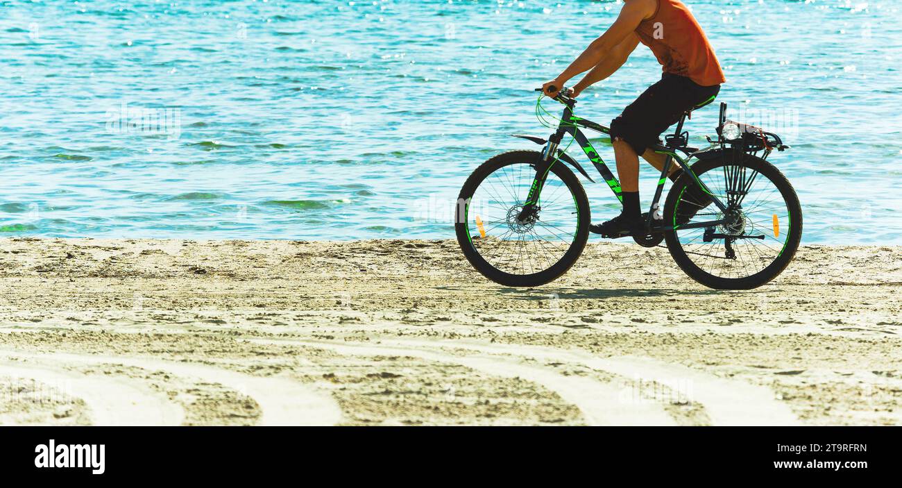 Unrecognizable biker man riding the titan mountain bike along sunny sandy beach Stock Photo - Alamy