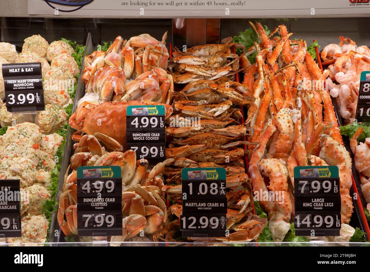 Fresh seafood at a grocery store including whole crab, crab legs, and ...