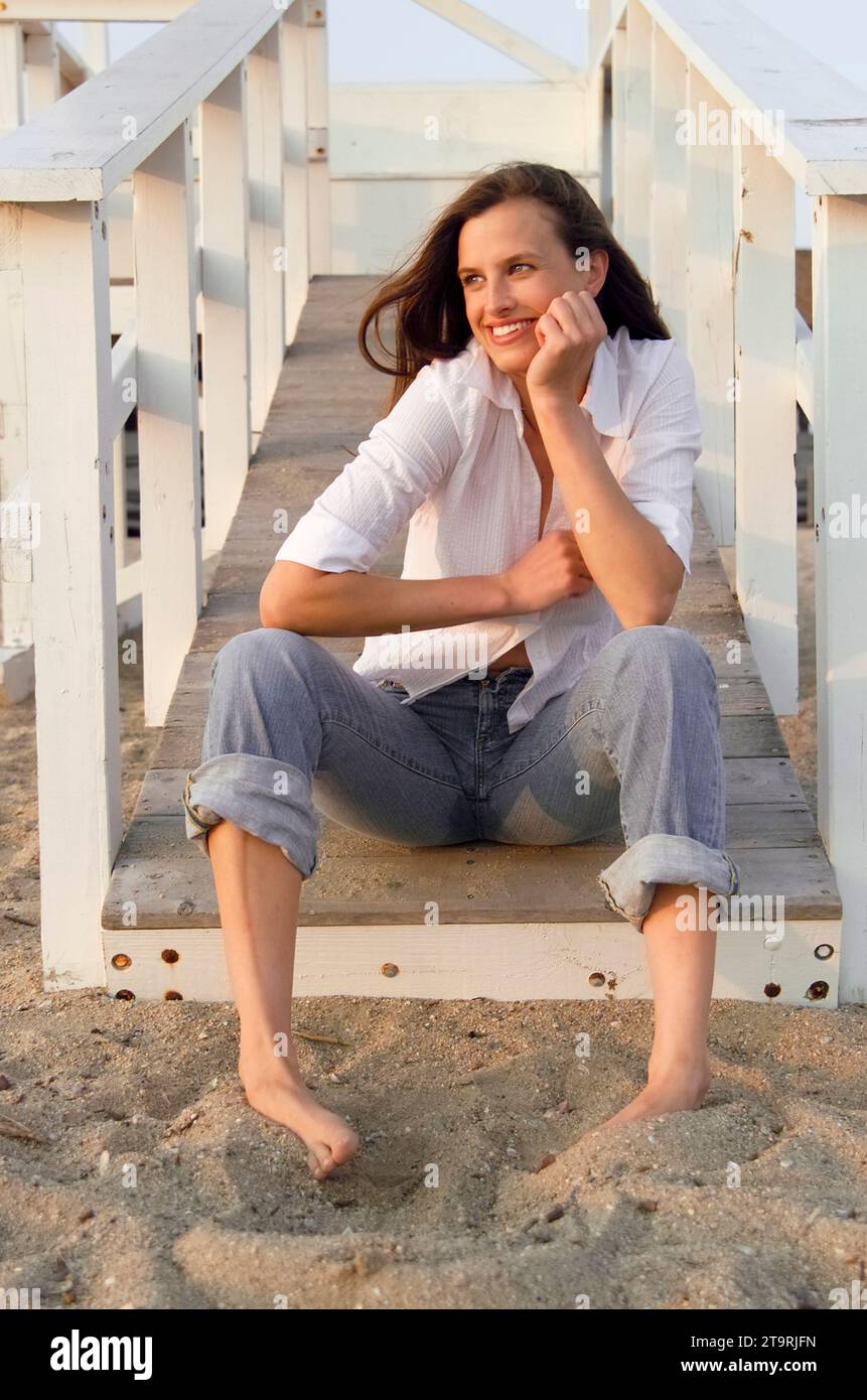 A woman watches the sunset from the boardwalk at Hammonasset Beach in ...