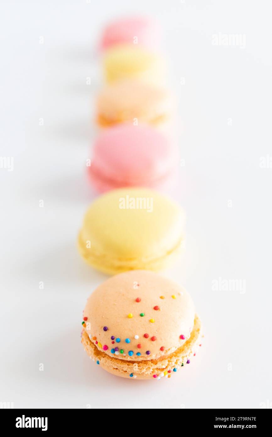 Lay flat of Colorful macarons with sprinkles on a white background ...