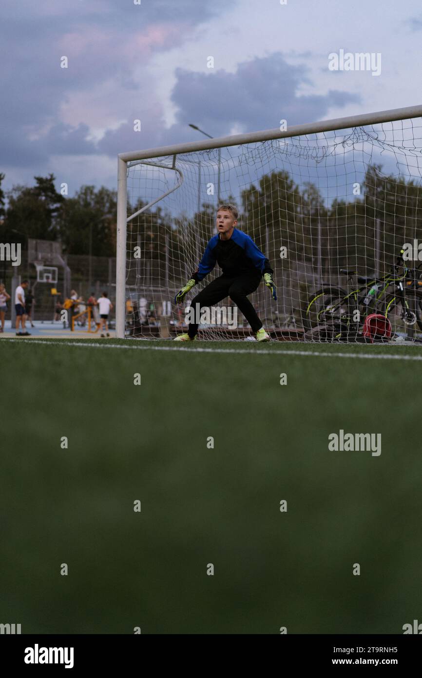 Kids playing soccer, boy goalkeeper catches ball in goal Stock Photo ...
