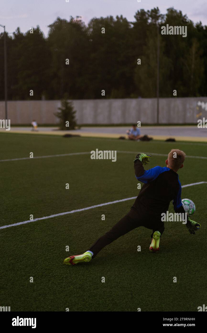Kids playing football, boy goalkeeper catches ball in goal Stock Photo ...