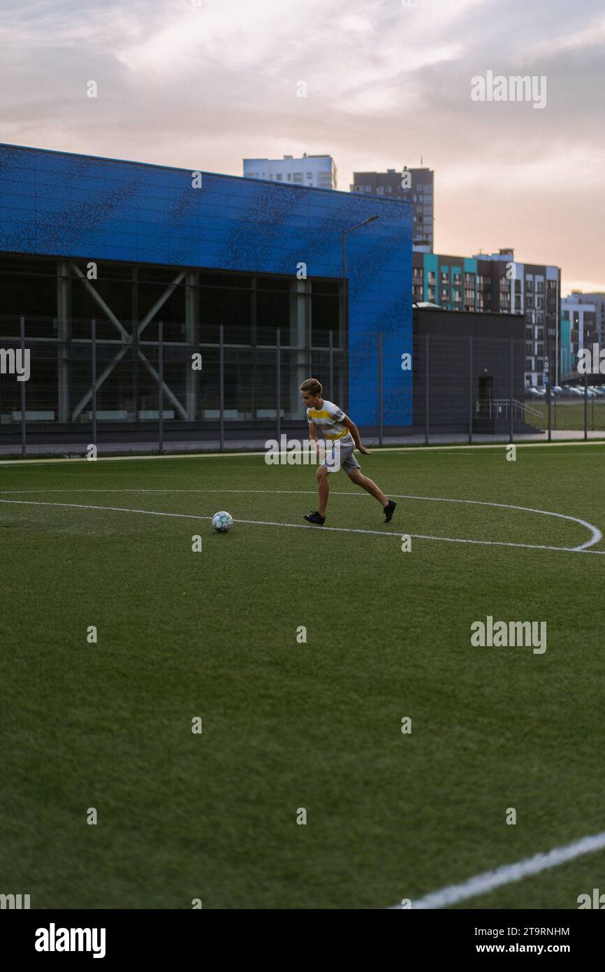 Children boys playing football, open school field Stock Photo - Alamy
