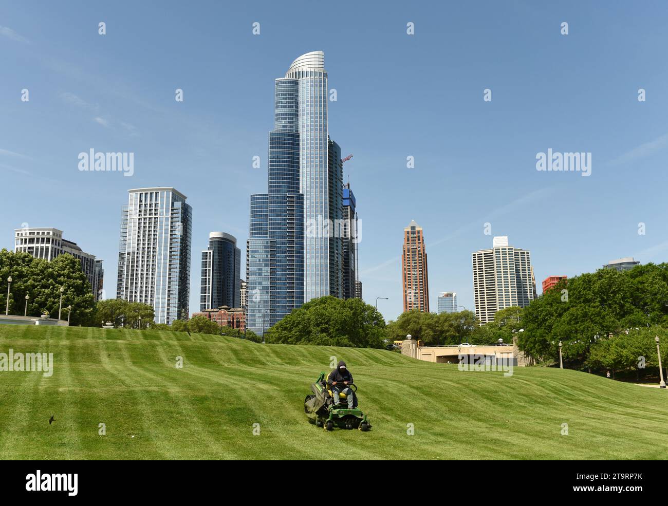 Chicago, USA - June 05, 2018: Worker mowing grass in The Great Ivy Lawn ...