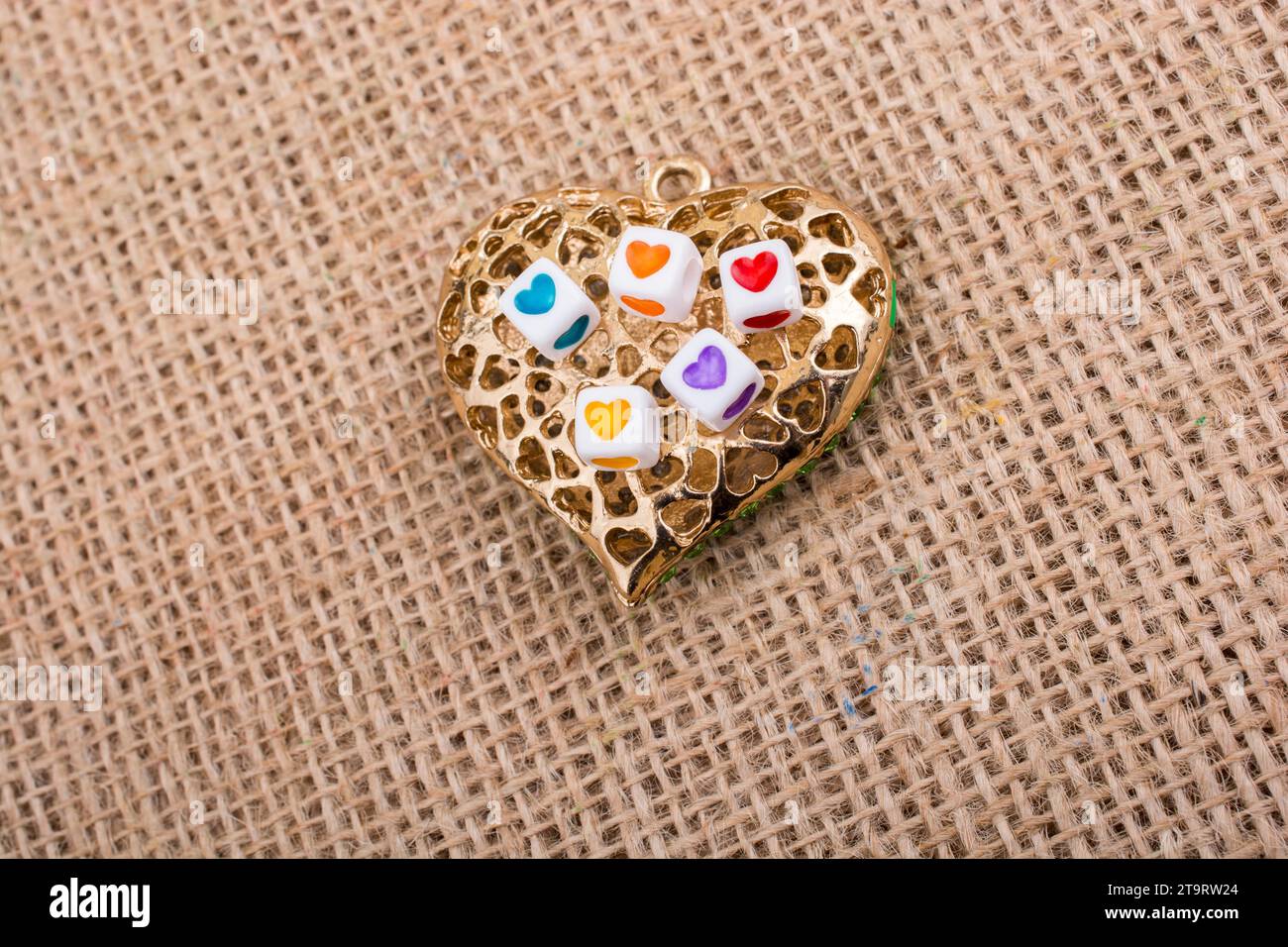 Heart cubes on Heart shaped gold color object Stock Photo - Alamy