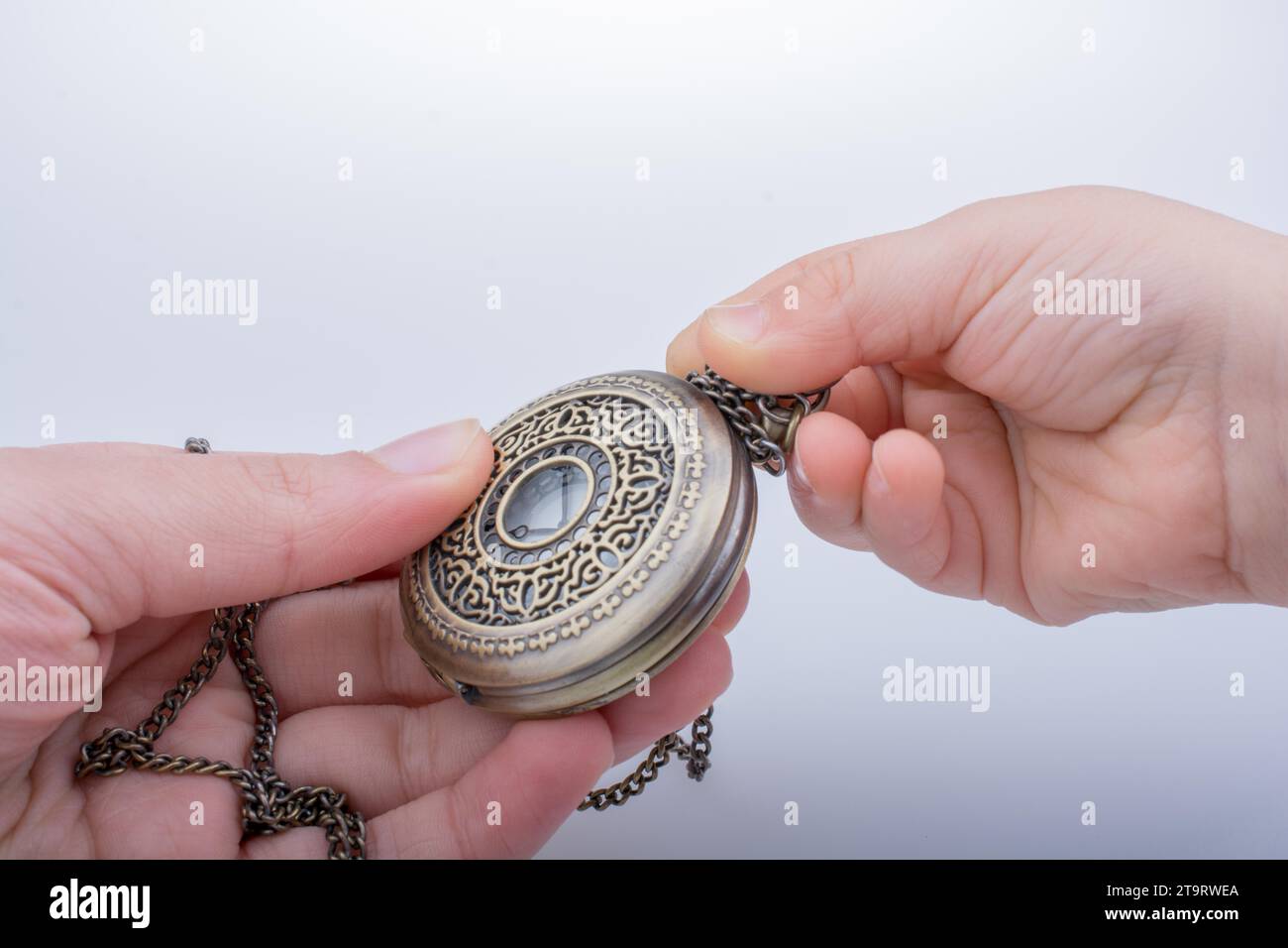Retro style pocket watch in hand on white background Stock Photo - Alamy