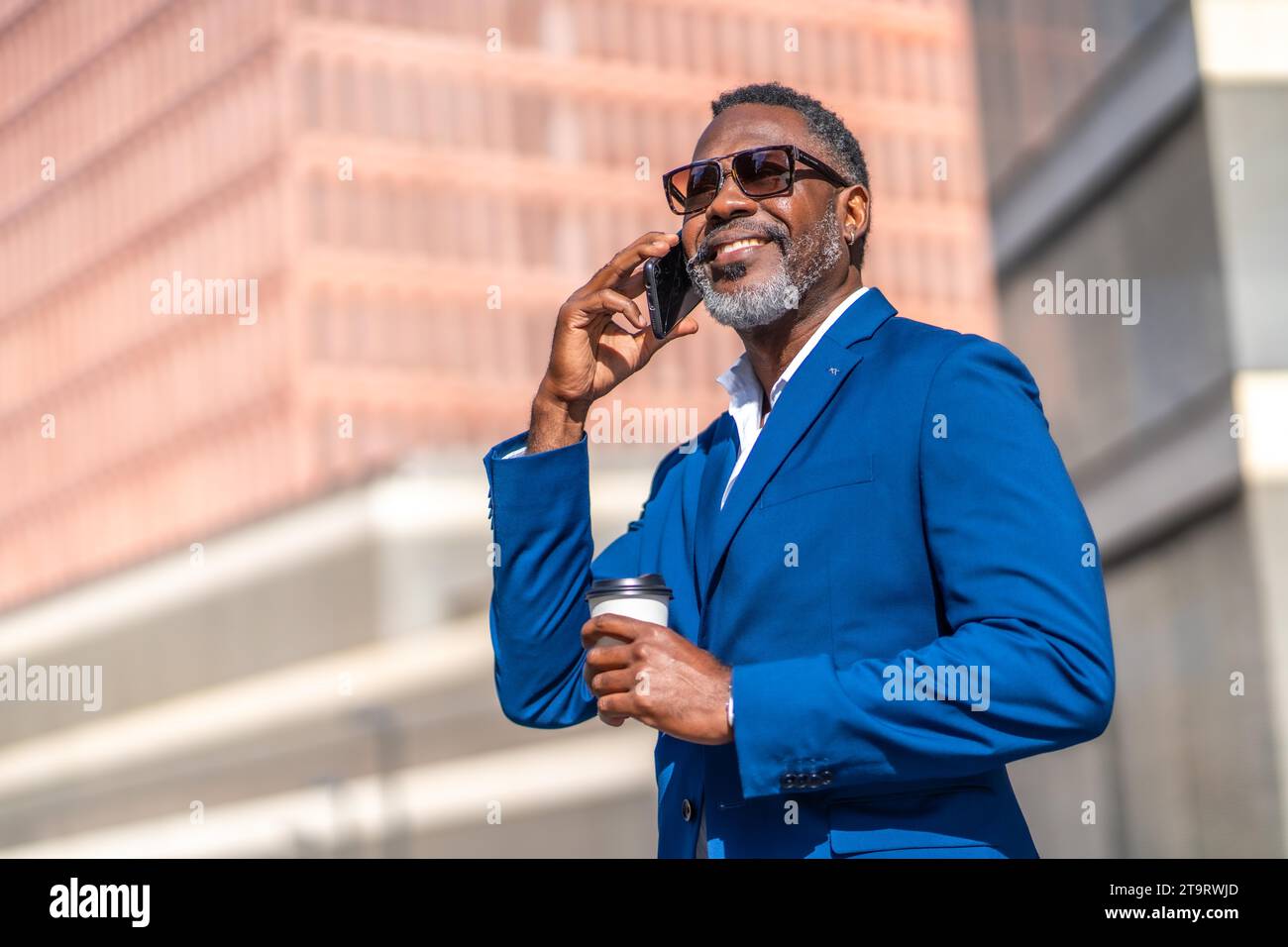 Low angle view portrait of a successful african businessman talking to ...