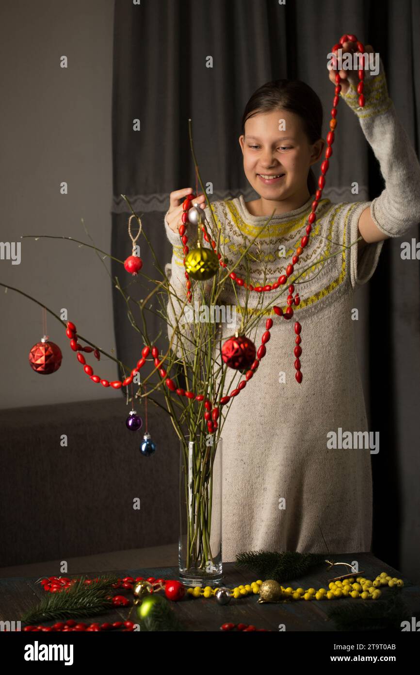 Children make garlands with their own hands. Red rosehip garlands using ...