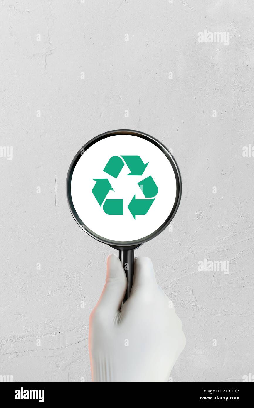 An employee's hand holds a magnifying glass for inspecting materials or ...