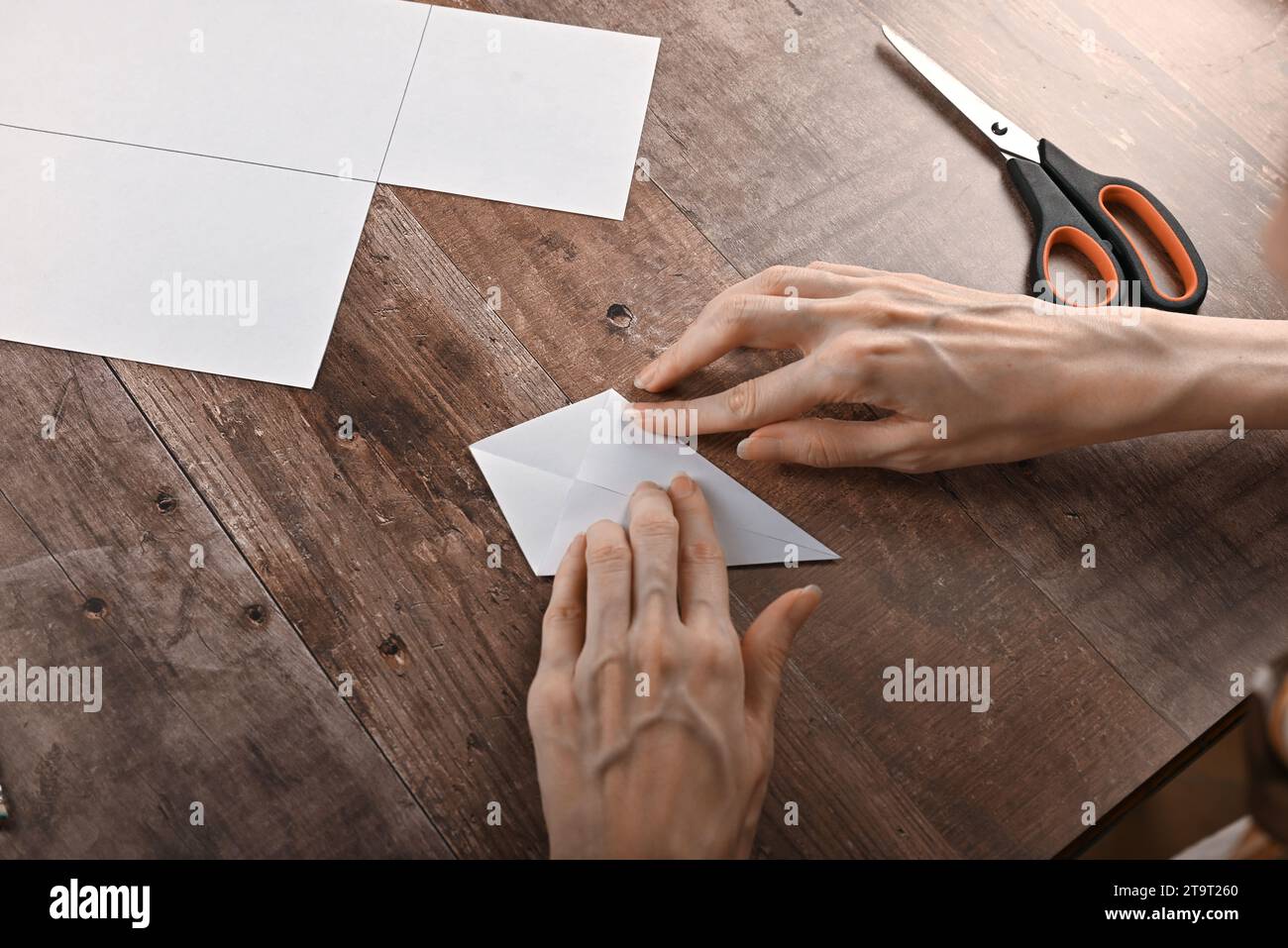 hands of an elderly woman fold origami paper. Creating an origami paper ...