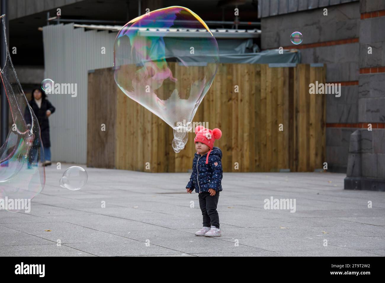 child looking at large soap bubbles near the cathedral, Cologne ...