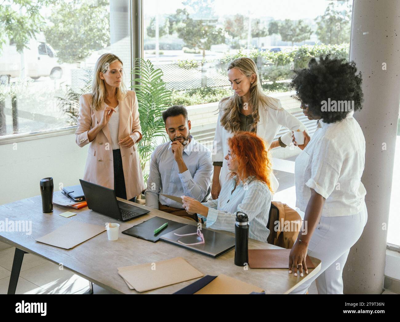 Group of work colleagues discussing about a new project while working ...