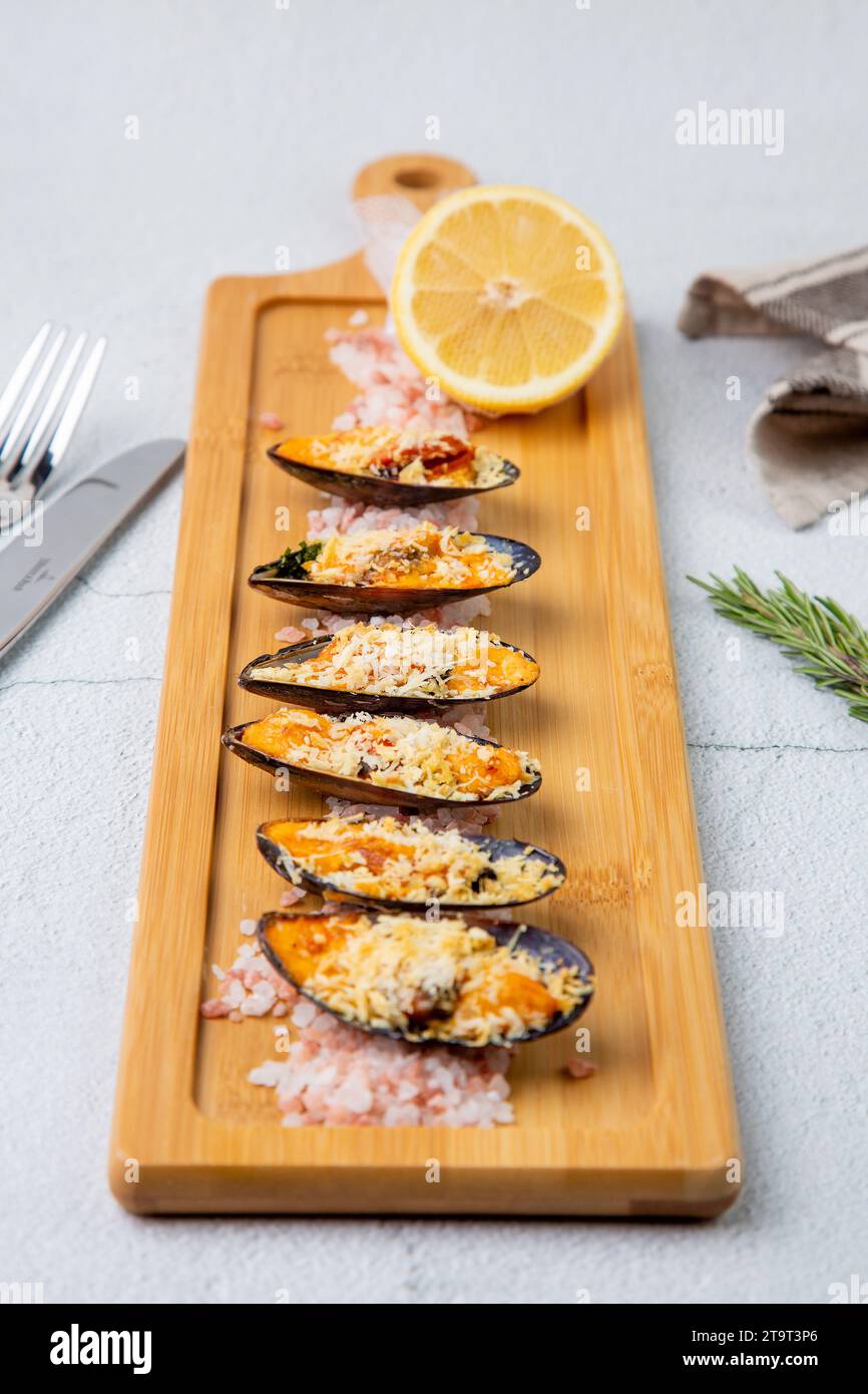 oysters scallops with red sea salt and citric acid on a wooden tray ...