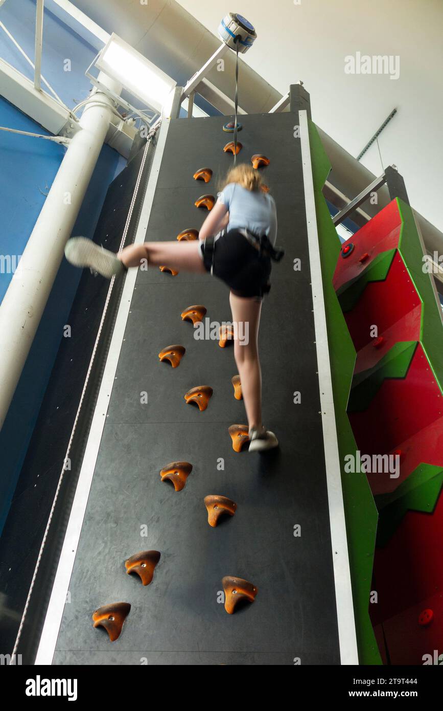 Nine year old girl / age 9 years kid on an indoor climbing wall, with ...