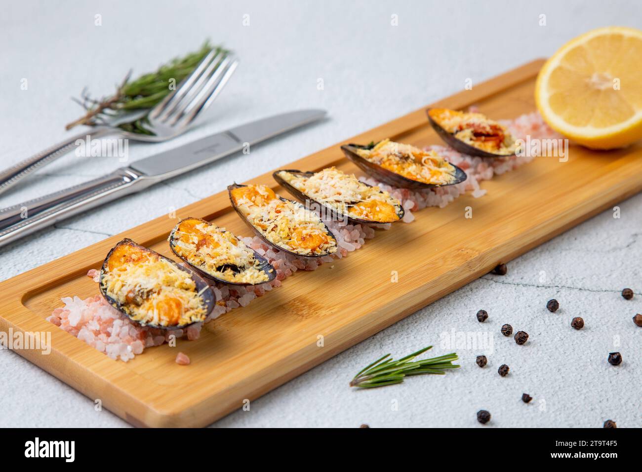 oysters scallops with red sea salt and citric acid on a wooden tray ...