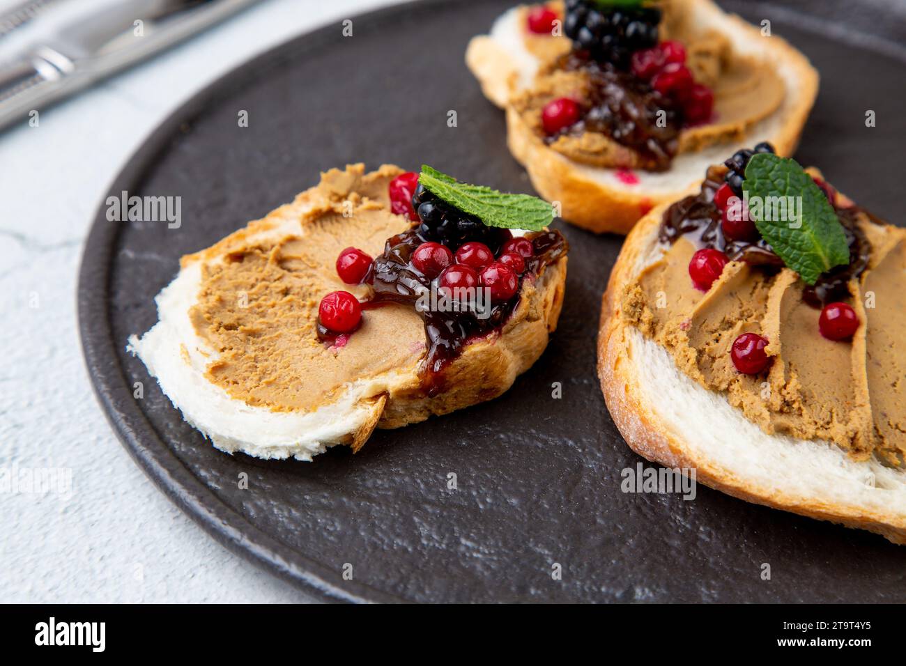 canapes with pate, mint leaves and berries, side view Stock Photo - Alamy