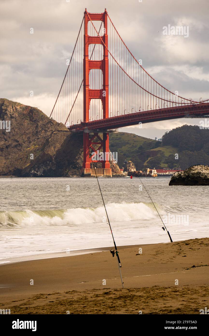 Fishermens rods planted in the sand infront of the golden gate bridge ...