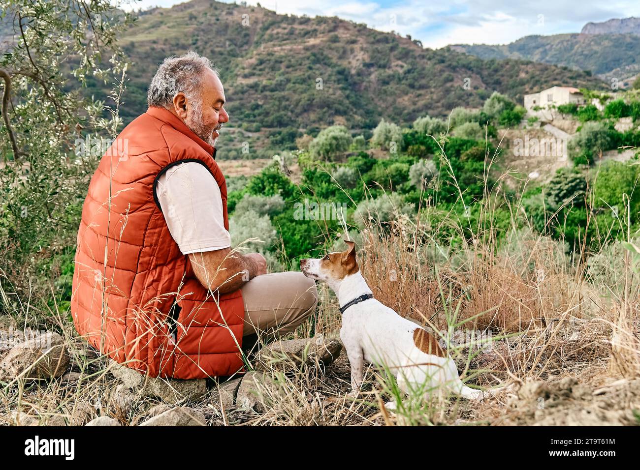 Mature gray haired man spending time outdoors with his small cute Jack ...