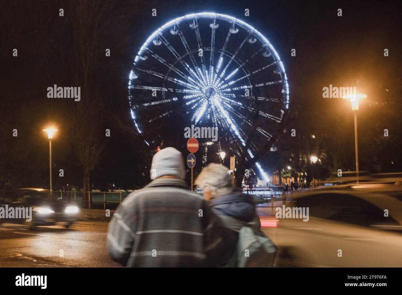 A Nighttime Stroll: Elders by the Ferris Wheel Stock Photo - Alamy