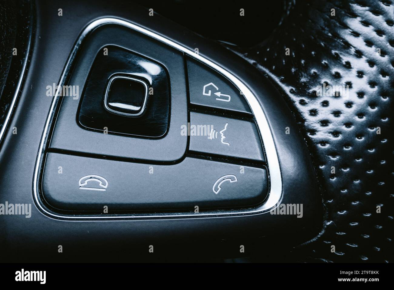 Modern car steering wheel with buttons and switches. Close up shot ...