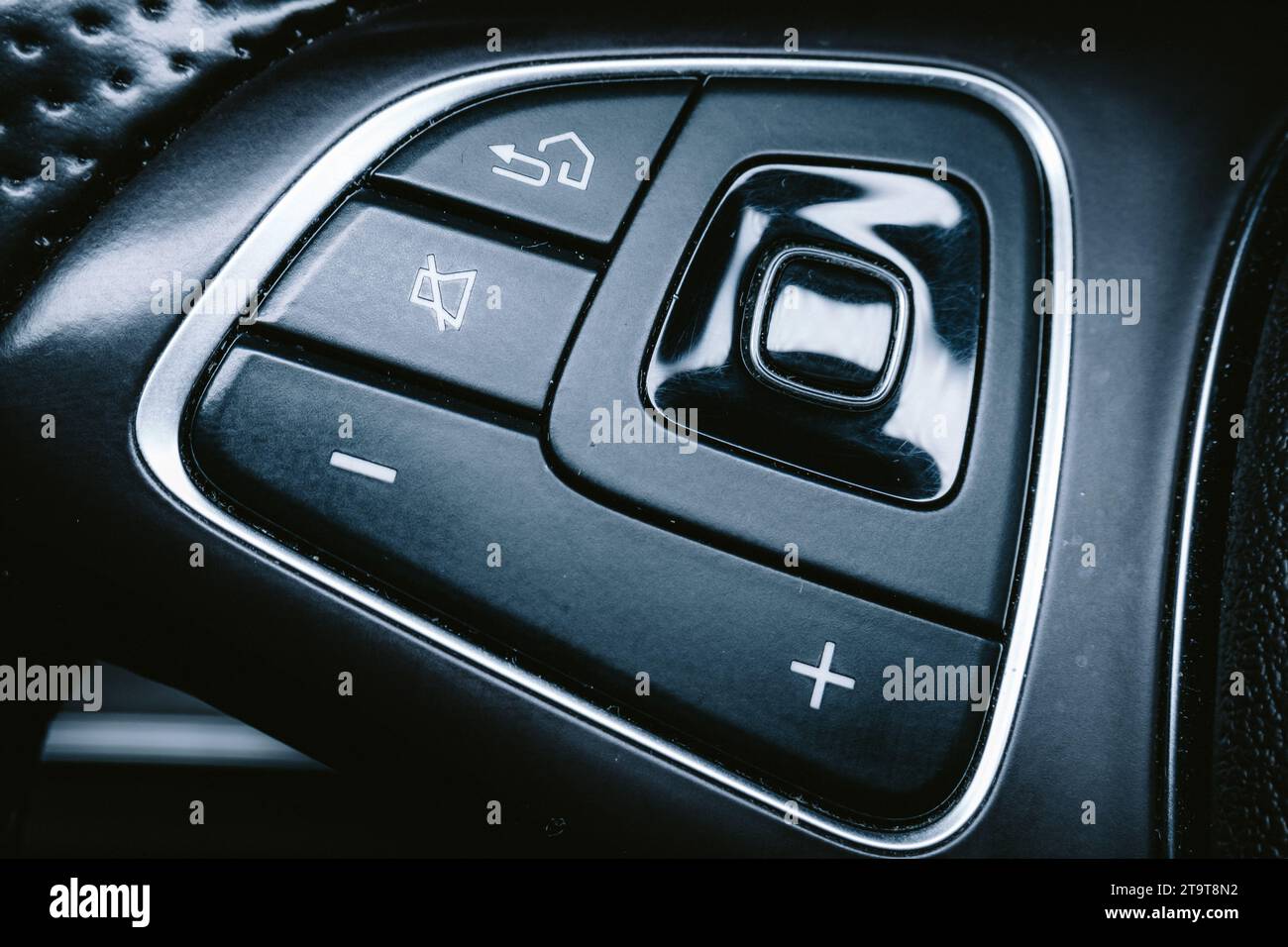 Modern car steering wheel with buttons and switches. Close up shot ...