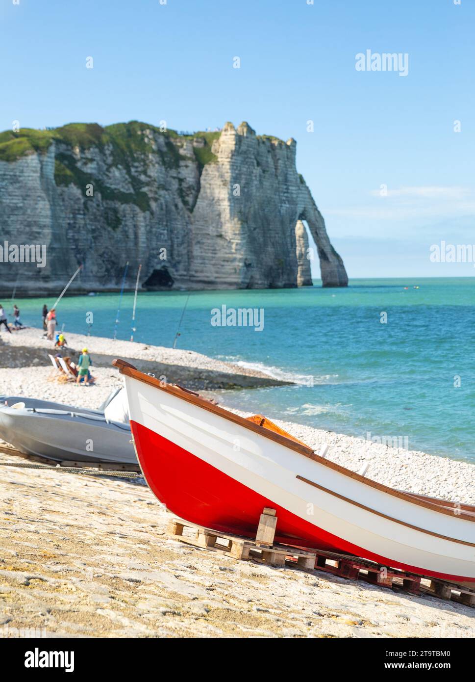 A red boat standing on the seashore with elephant like sea cliff in the ...