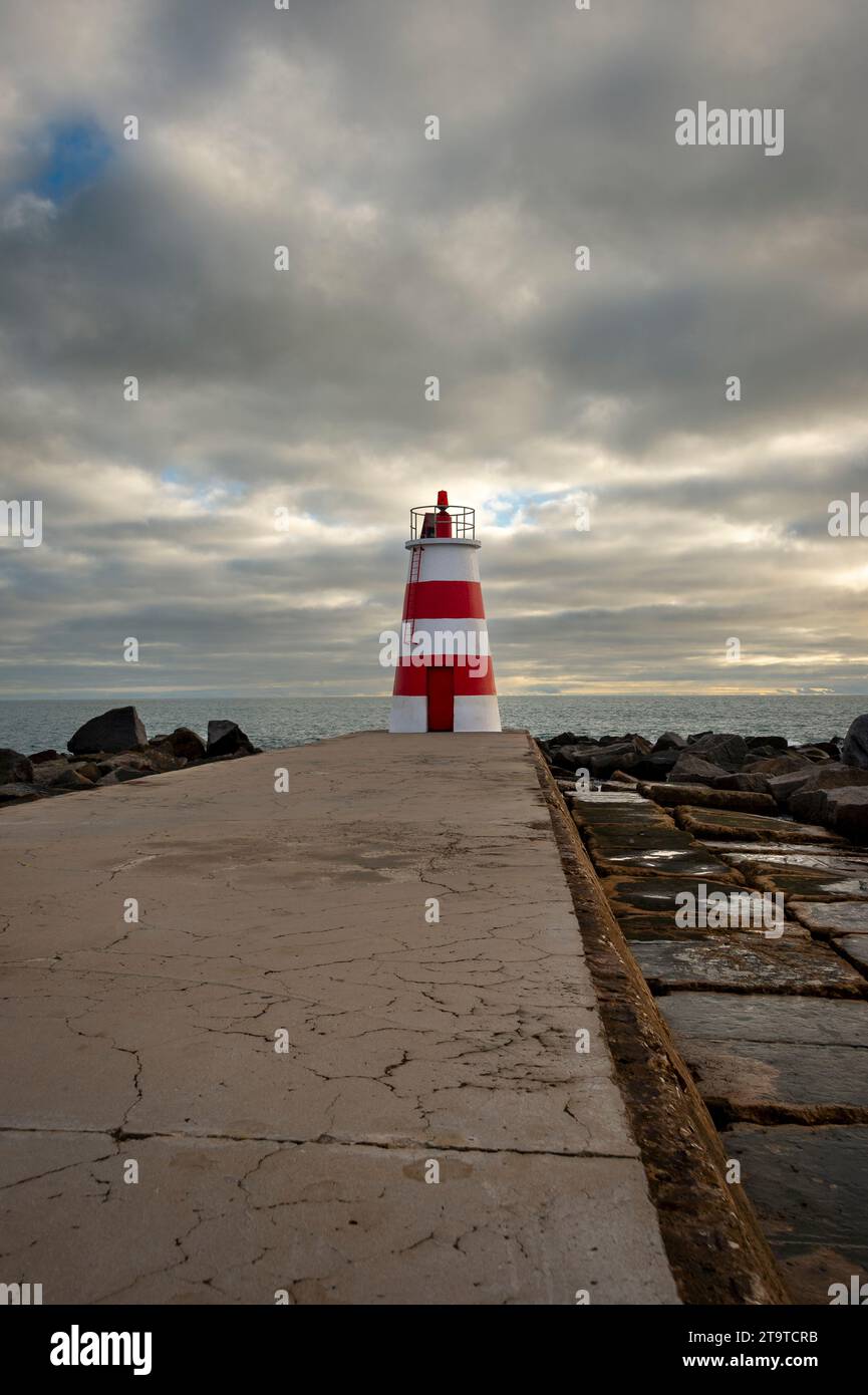 Red and white striped lighthouse beacon at the end of a causeway Stock ...
