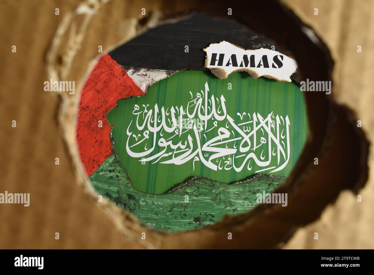 View through the hole. The word Hamas written on burnt paper, Palestine ...