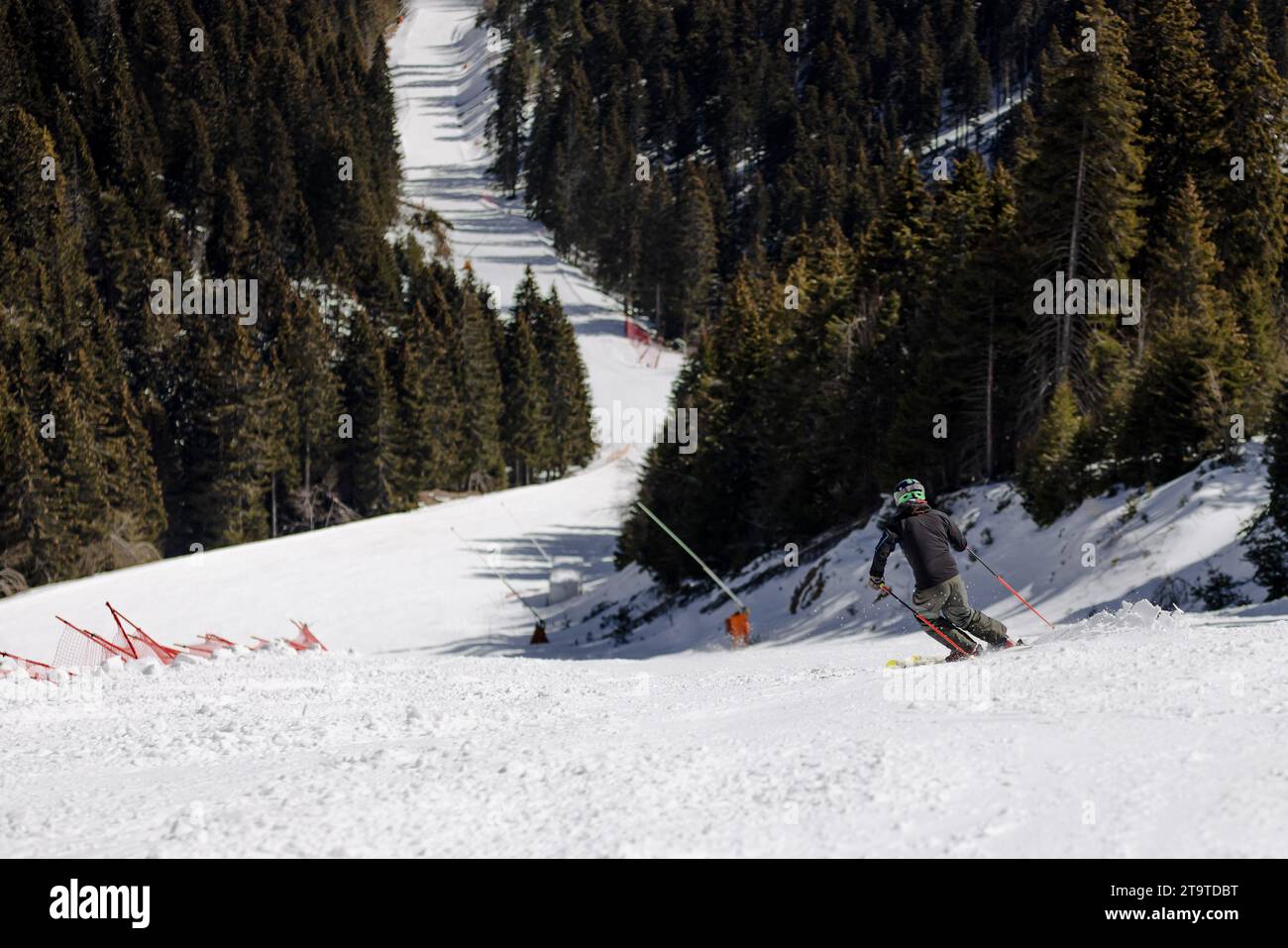 Professional skier skiing on slopes in a mountain winter resort. Sunny ...