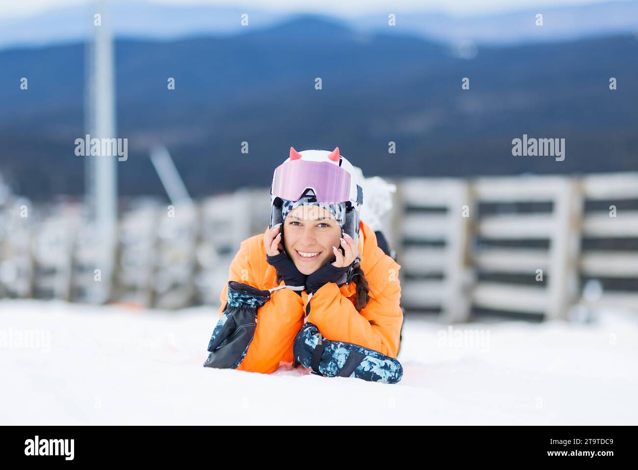 Skier girl posing laying on the snow Stock Photo - Alamy