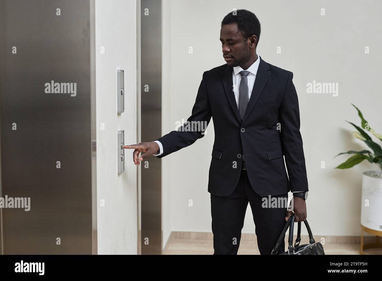 Medium full shot of African American businessman wearing suit reaching ...
