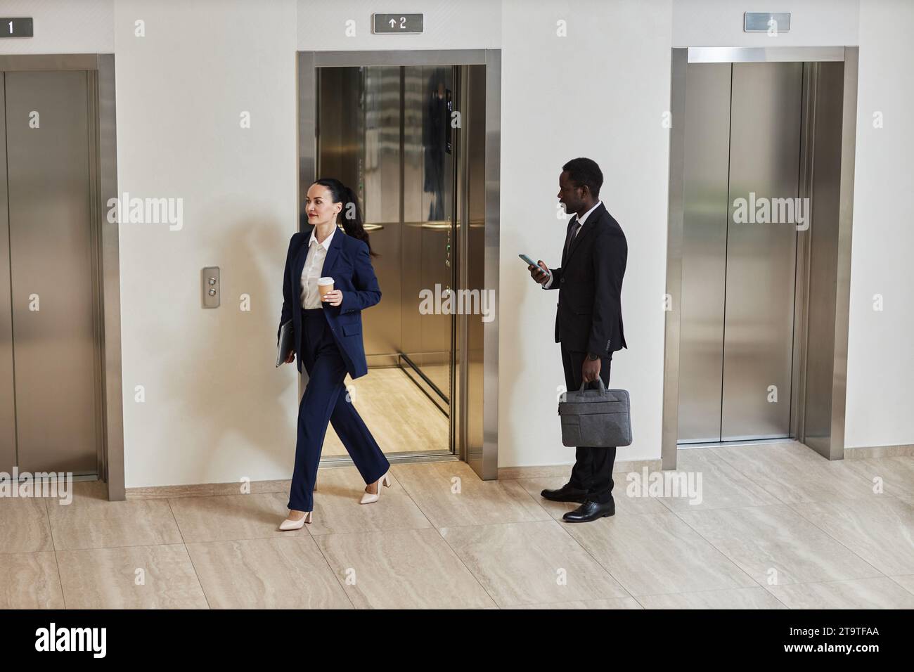 Wide shot of African American businessman holding phone and bag looking ...