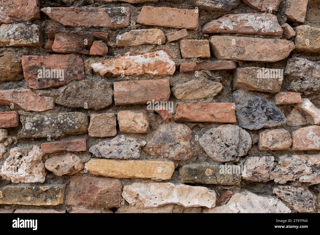 Textured, abstract pattern formed by old, weathered brick and stone ...