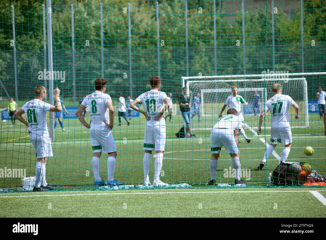 Group of men substitutes football players in uniform watching the match ...