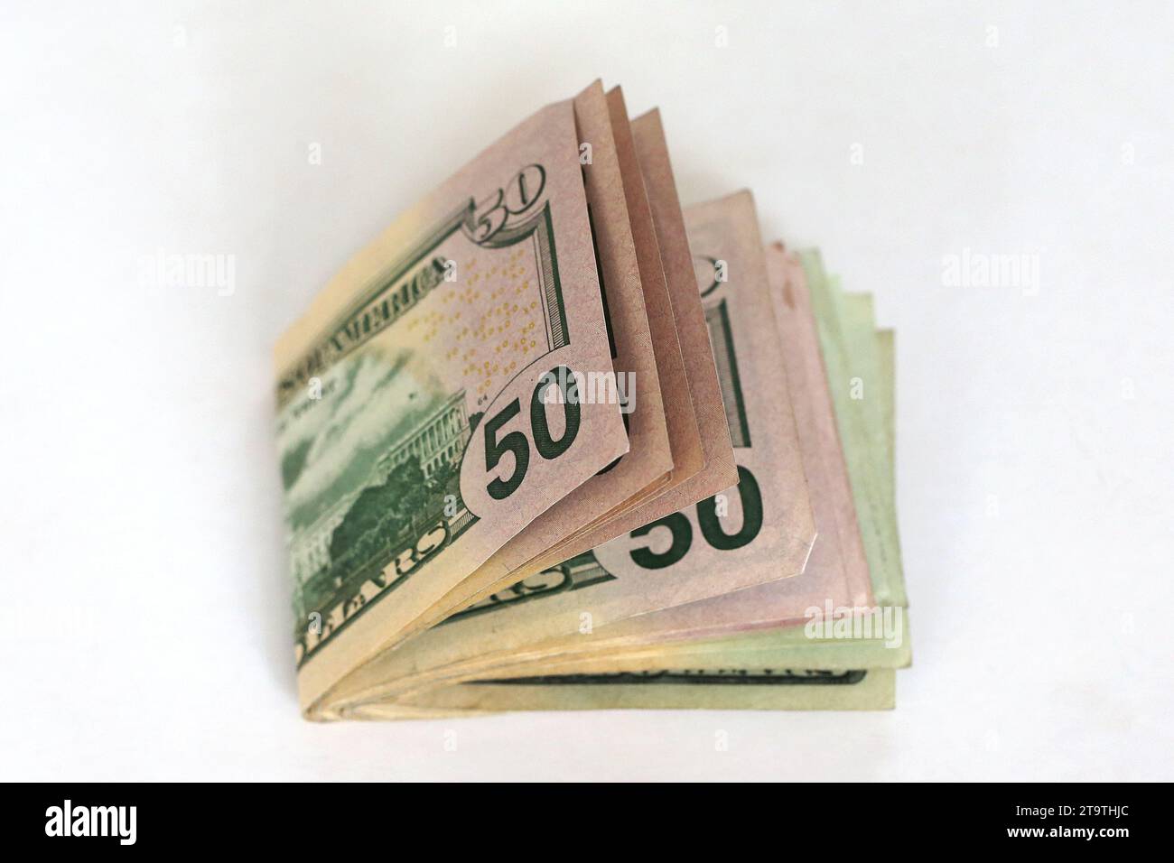 A wad of dollar notes on a white background Stock Photo - Alamy
