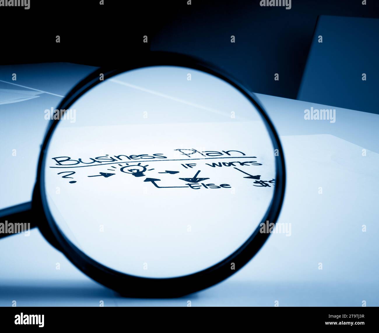 business-plan-words-see-through-lens-of-loupe-on-office-table-business