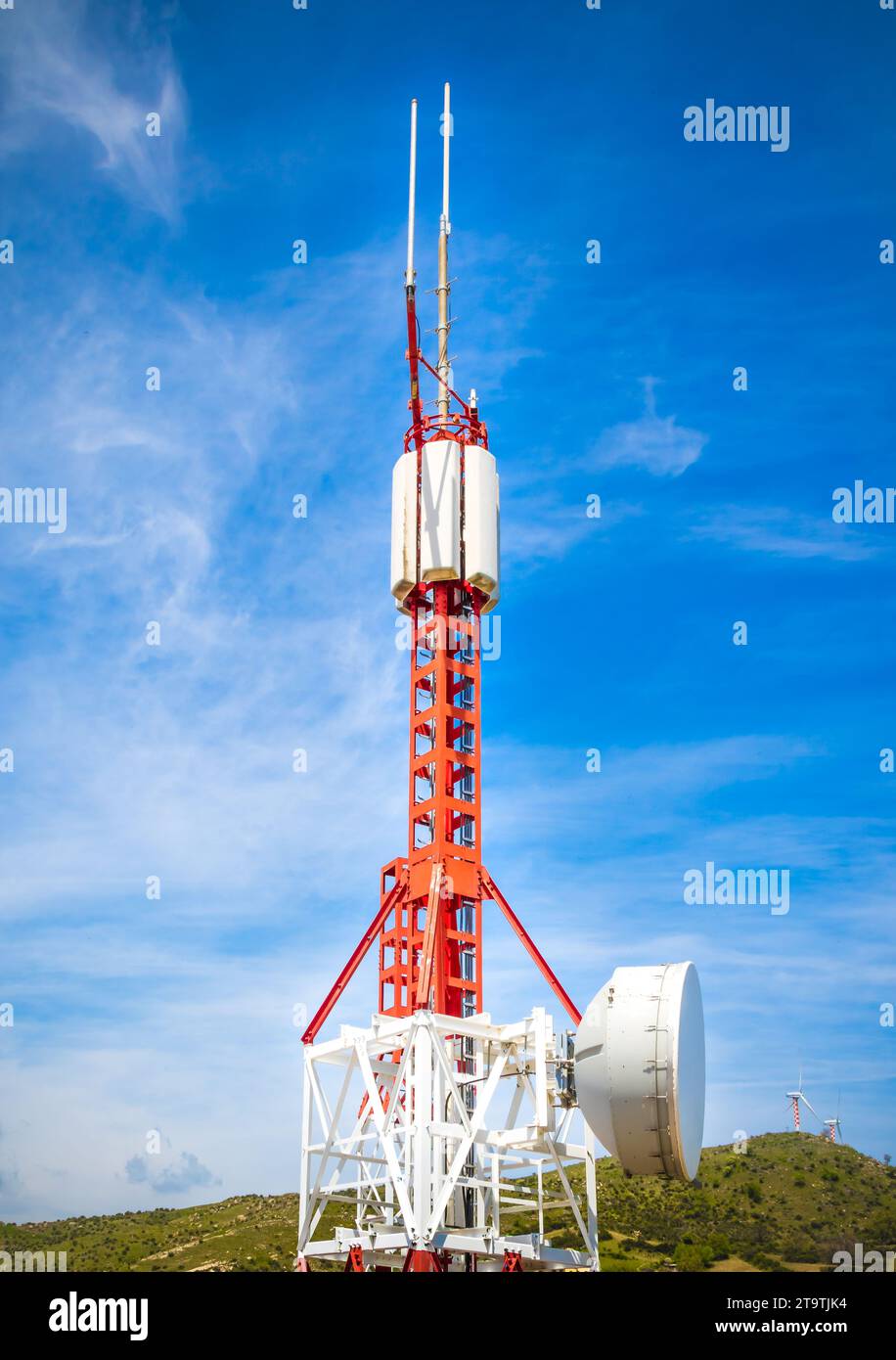 Mobile phone communication repeater antenna under blue sky and green ...