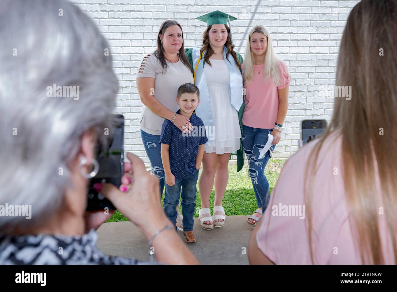 Khyli Barbee, 15, wearing mortar cap, poses for pictures with family ...