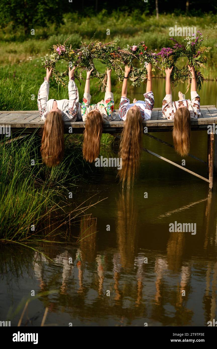 The girls are lying on the bridge near the pond and have raised woven ...