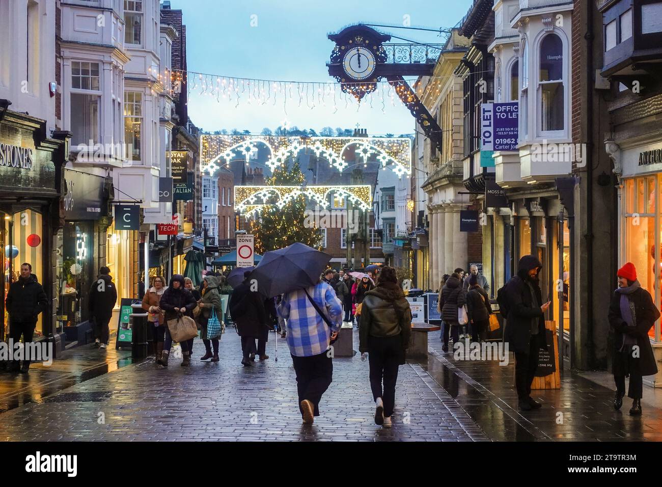 People shoppers walking along Winchester High Street in winter with ...