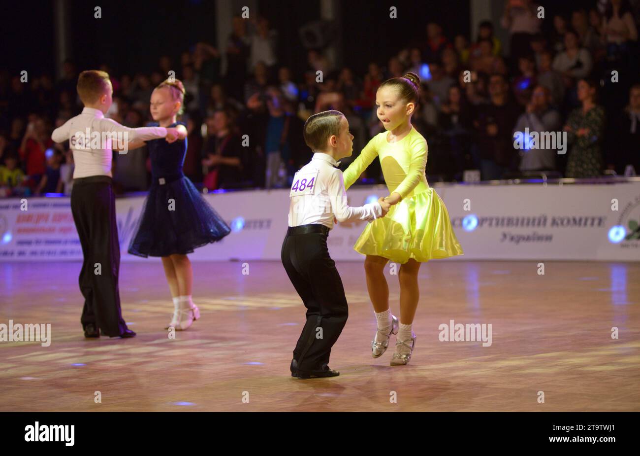 Little girls and boys dancing in pairs in the ballroom. Charity ball ...