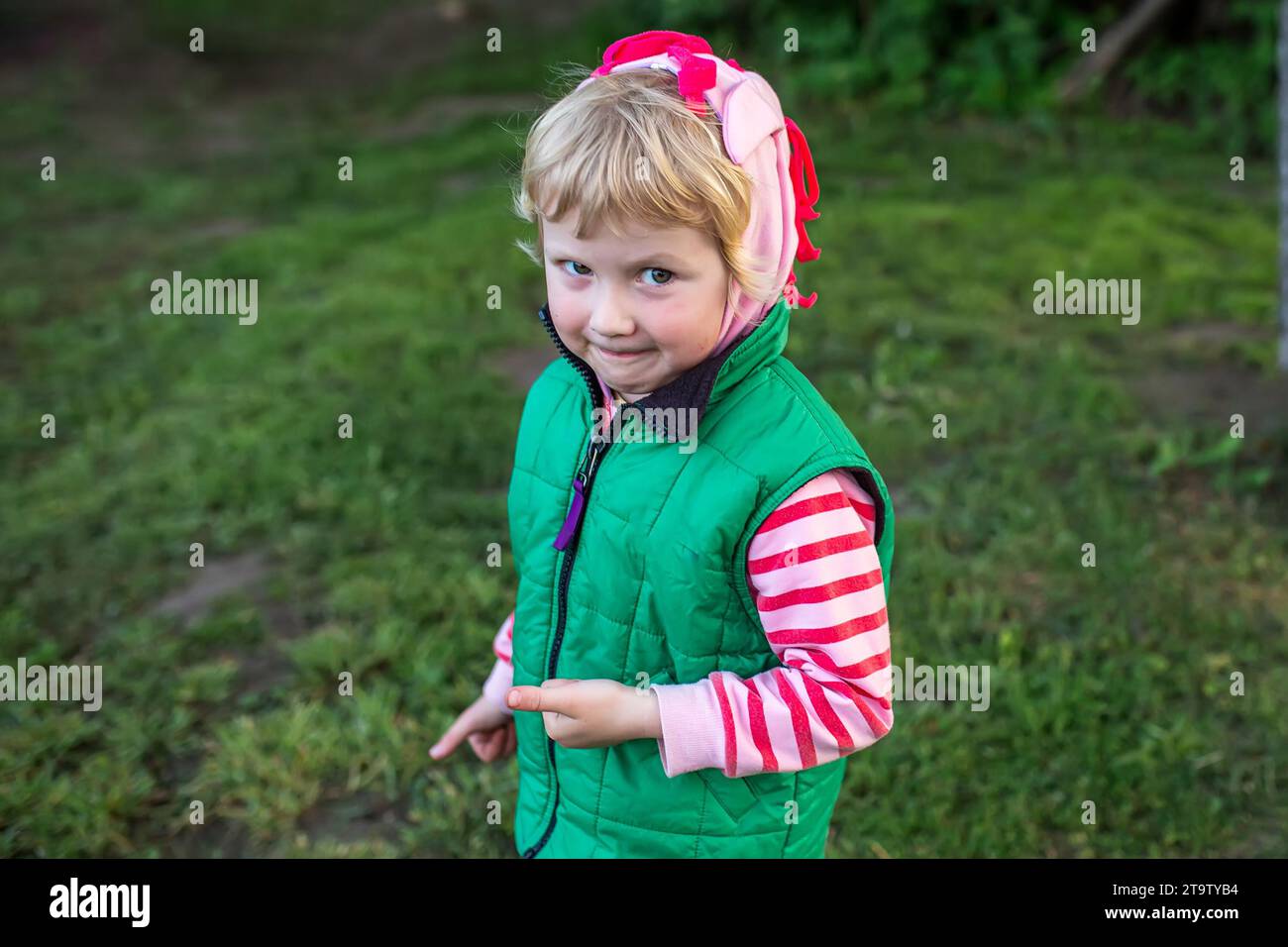 Funny little girl angry in green jelly on grass background Stock Photo ...