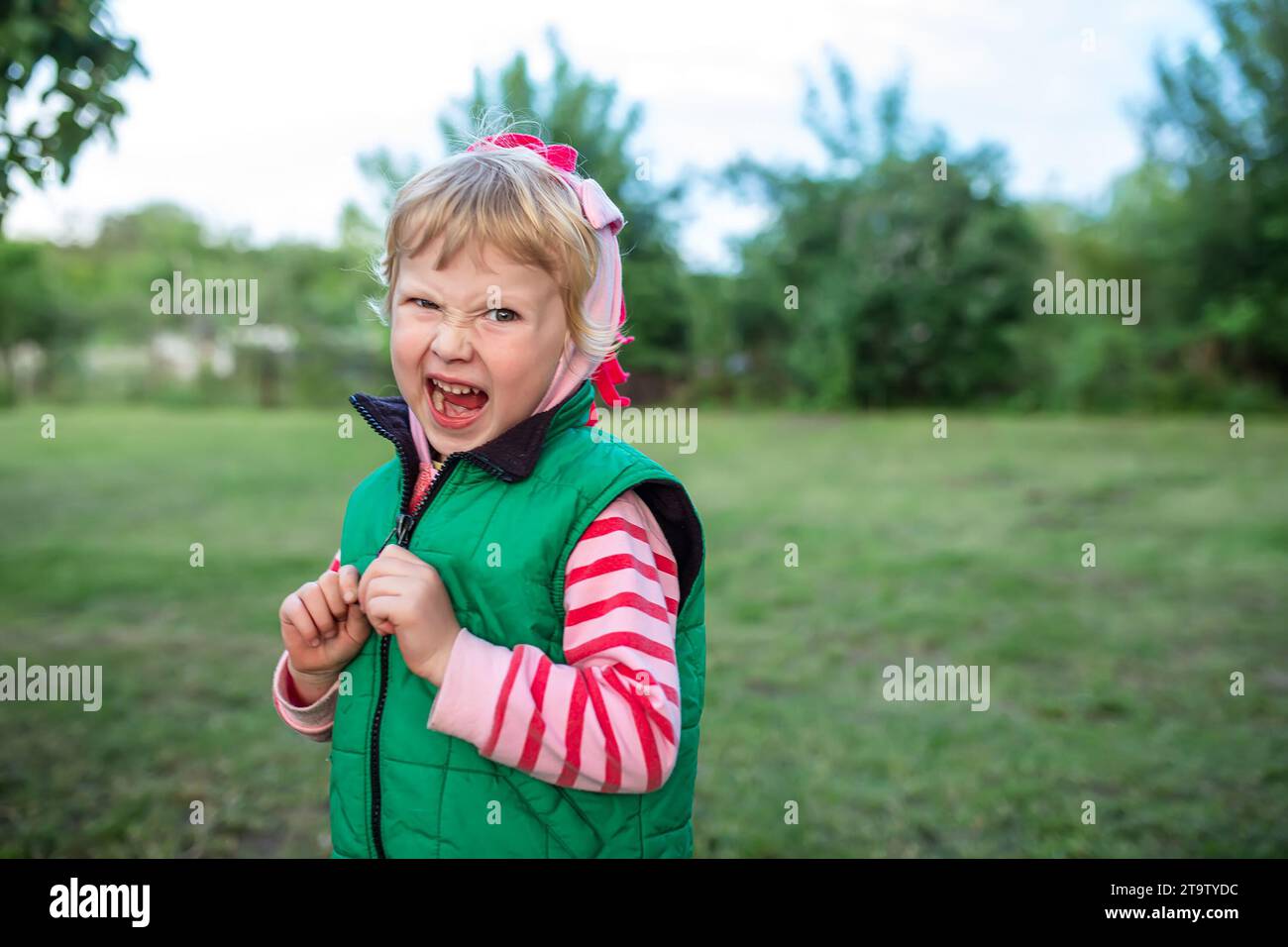 Funny little girl screaming with her mouth open against the background ...