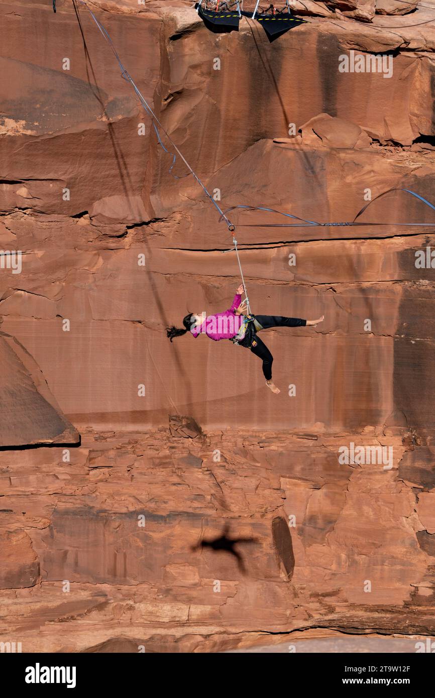 A female highliner loses her balance and falls off the highline, or ...