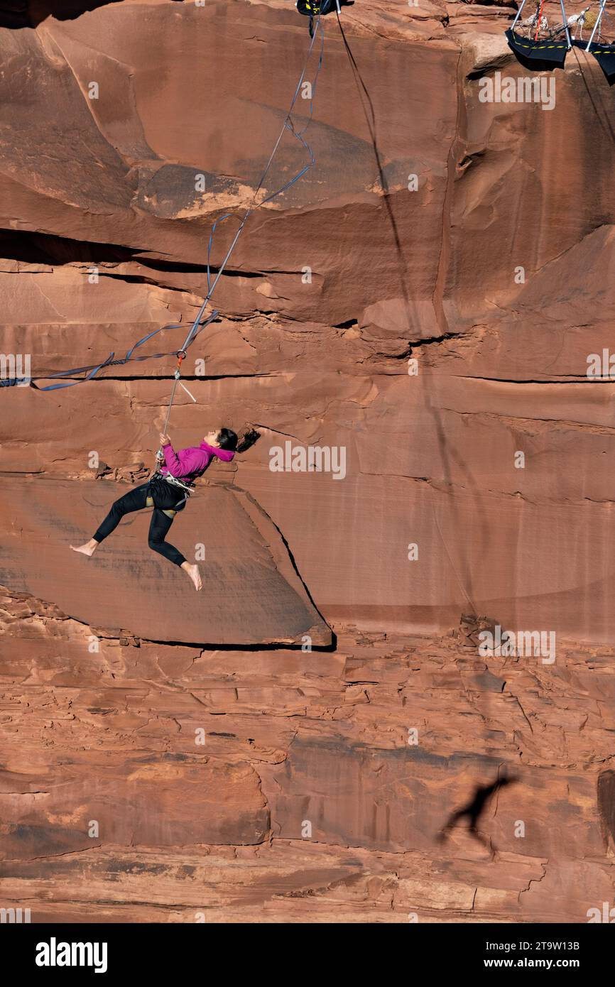A female highliner loses her balance and falls off the highline, or ...