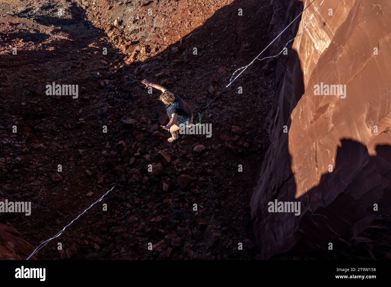 Aerial view of a young man highlining 500 feet above the canyon floor ...