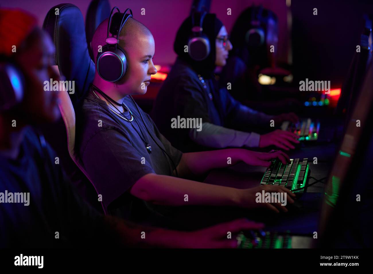 Side view portrait of gen Z young woman playing video games in ...