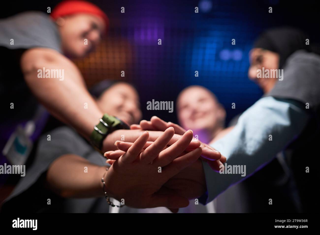 Low angle closeup of female team stacking hands in unity and ...